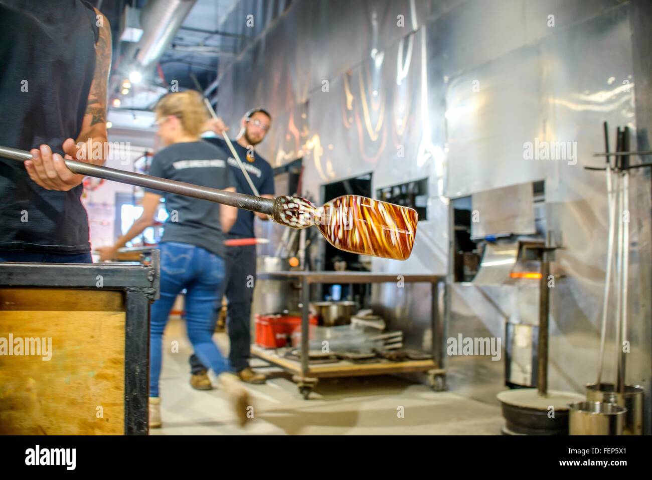 Group of young adults blowing glass Stock Photo - Alamy