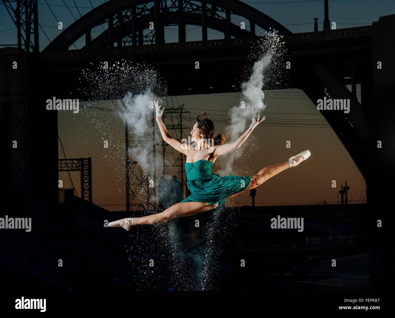 Female ballet dancer leaping whilst releasing powder explosion at ...