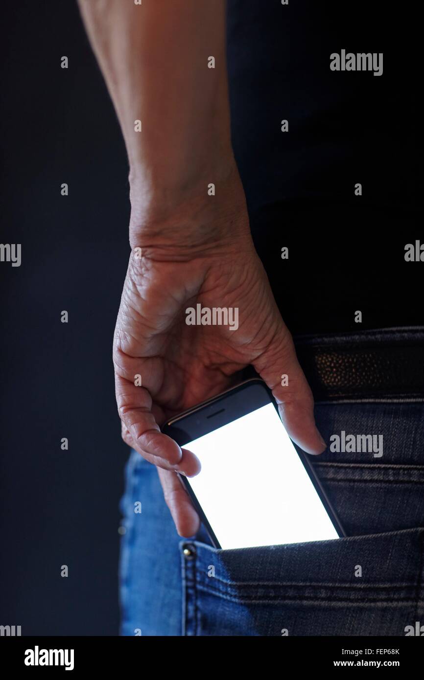Womans hand removing smartphone from back pocket Stock Photo - Alamy