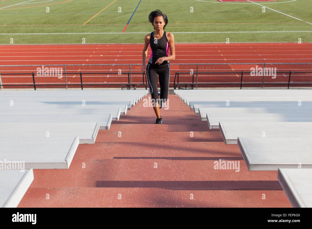 Young woman running up steps at sports track Stock Photo - Alamy