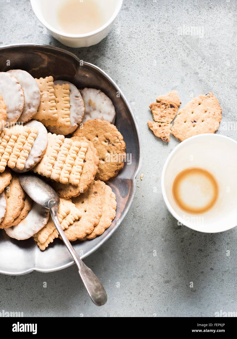 Overhead view of cookies in metal bowl and empty cups Stock Photo - Alamy