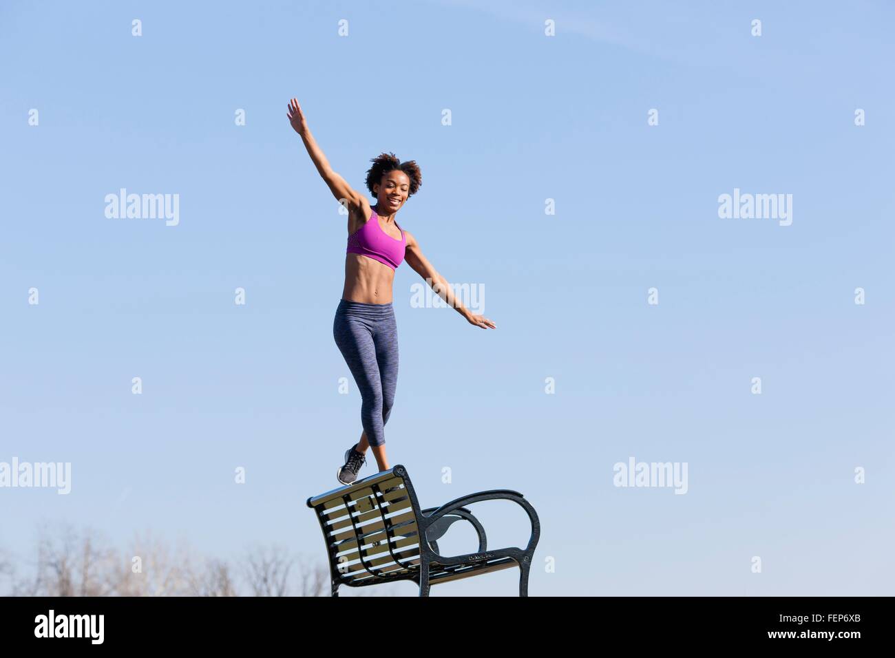 Young woman walking along edge of bench Stock Photo - Alamy