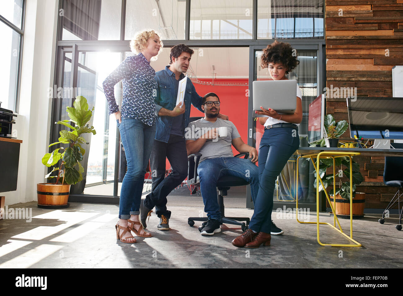 Multiracial group of designers meeting in modern office discussing work ...