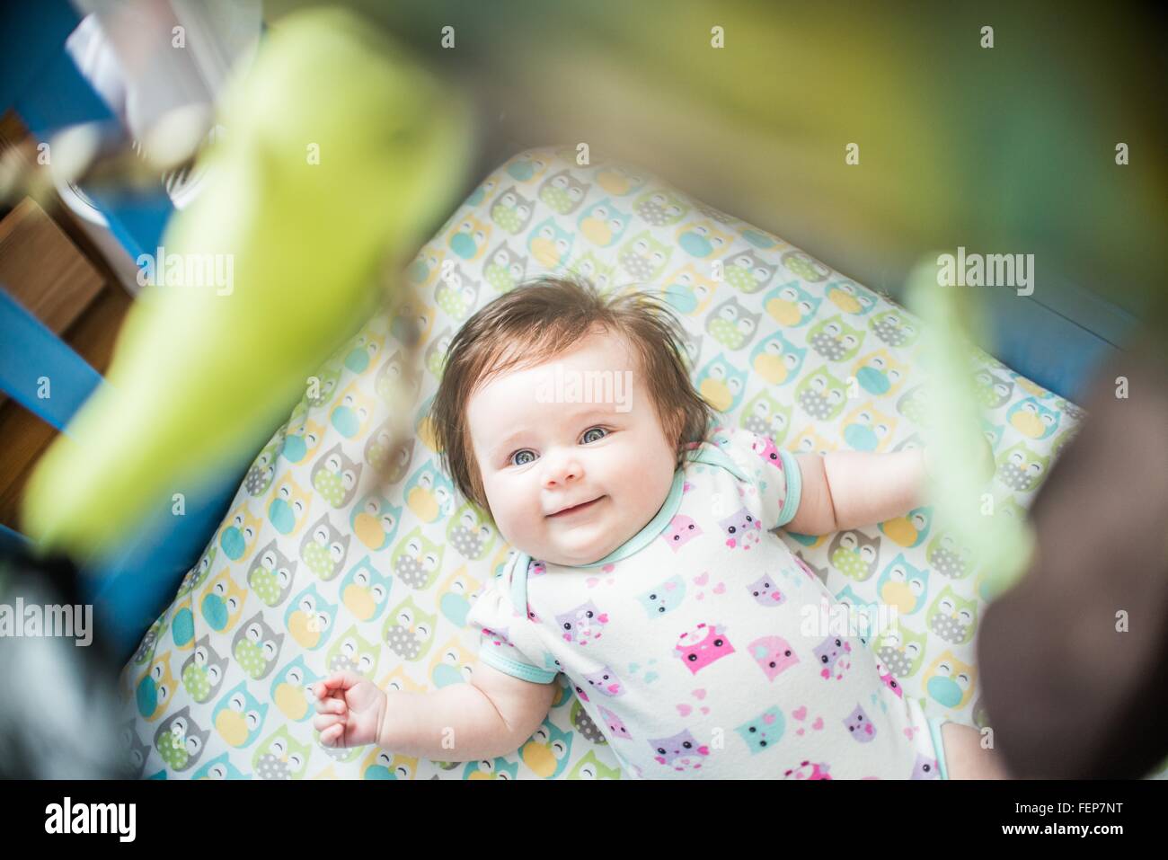 Overhead view of baby girl lying in crib smiling Stock Photo - Alamy