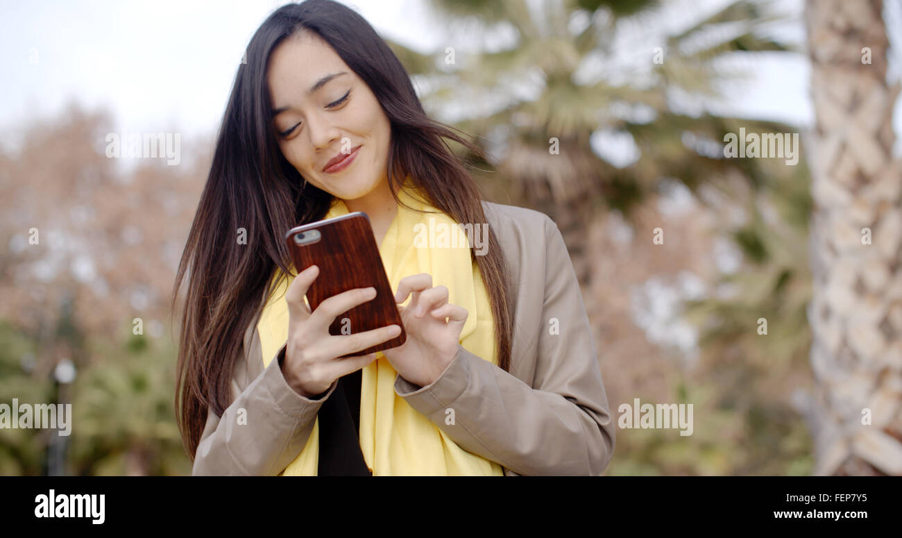 Happy young woman sending a text message Stock Photo - Alamy