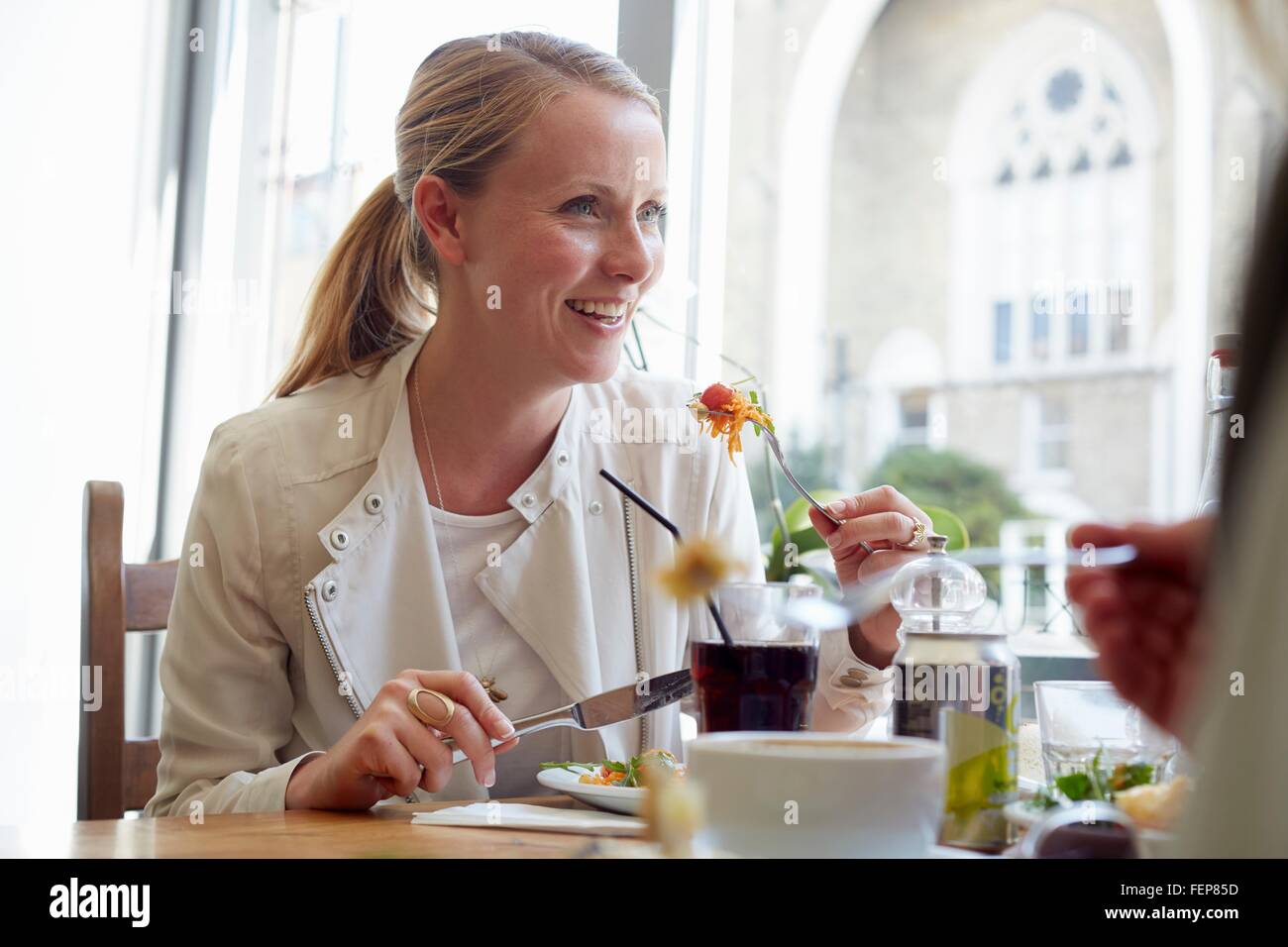 Mid adult woman having lunch with friend in cafe Stock Photo - Alamy