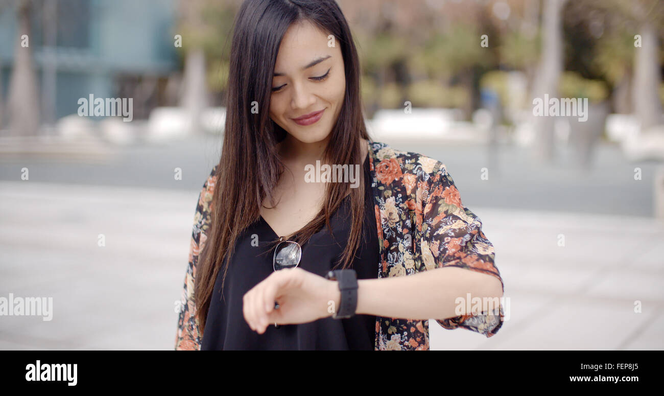 Young woman looking at the time with a smile Stock Photo - Alamy