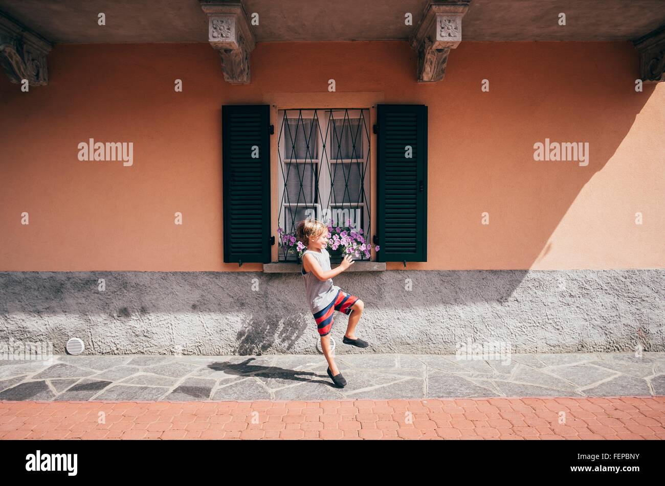 Boy running past window with shutters, Schruns, Vorarlberg, Austria ...