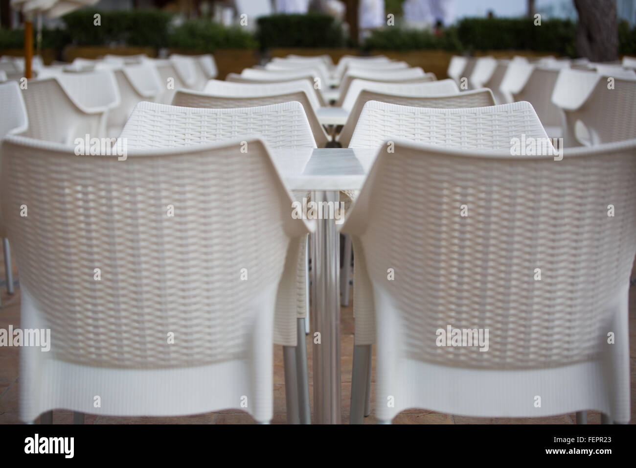 Perfectly aligned chairs and tables on an open air terrace in a holiday ...