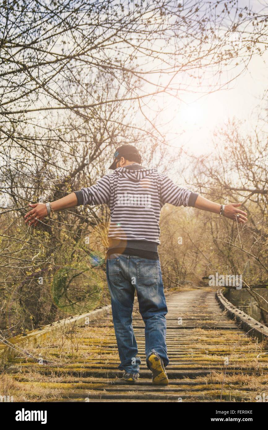 Rear View Of Man Walking On Bridge Stock Photo - Alamy