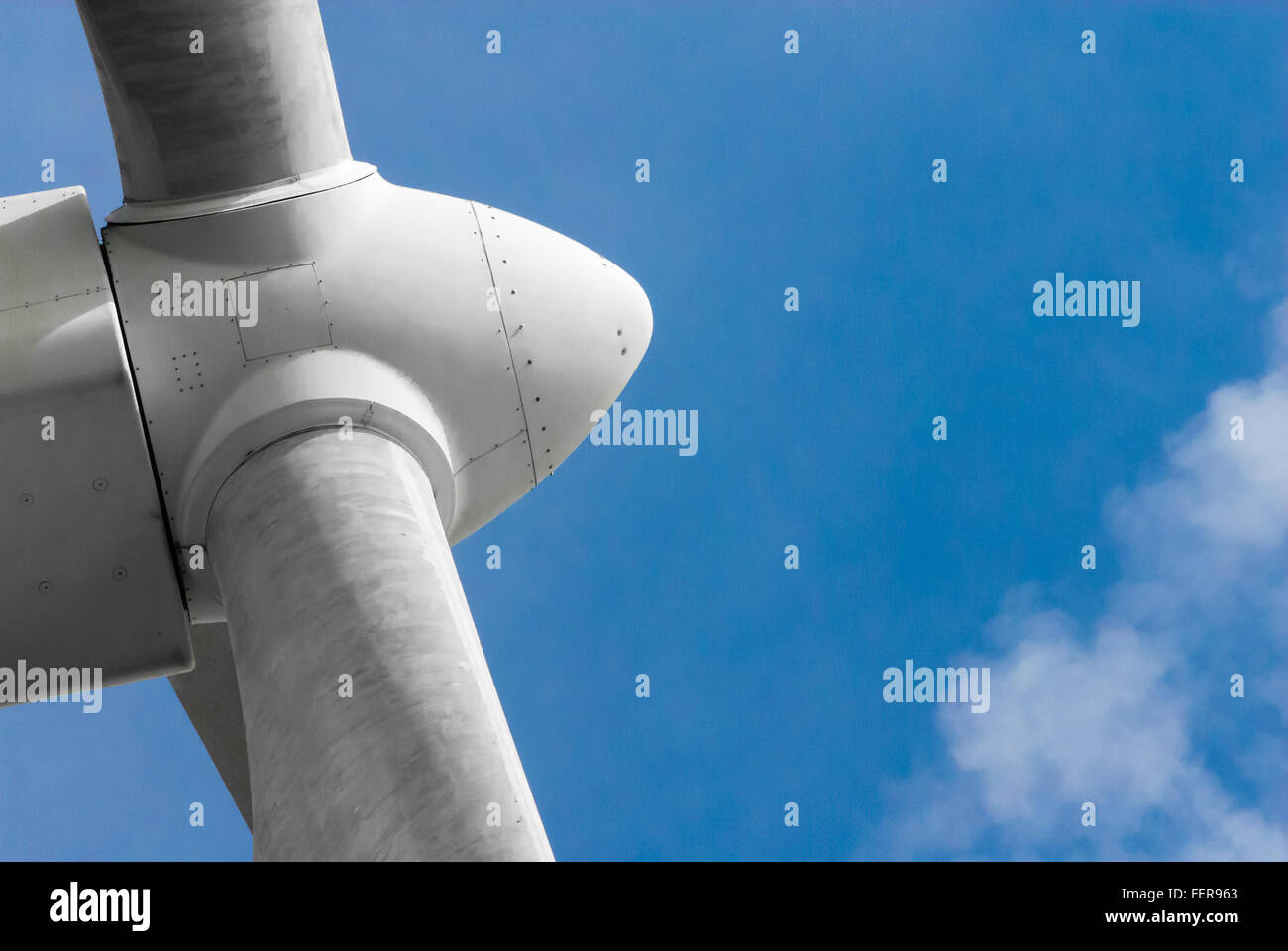 Close-up of white propeller head on wind turbine against blue sky and ...