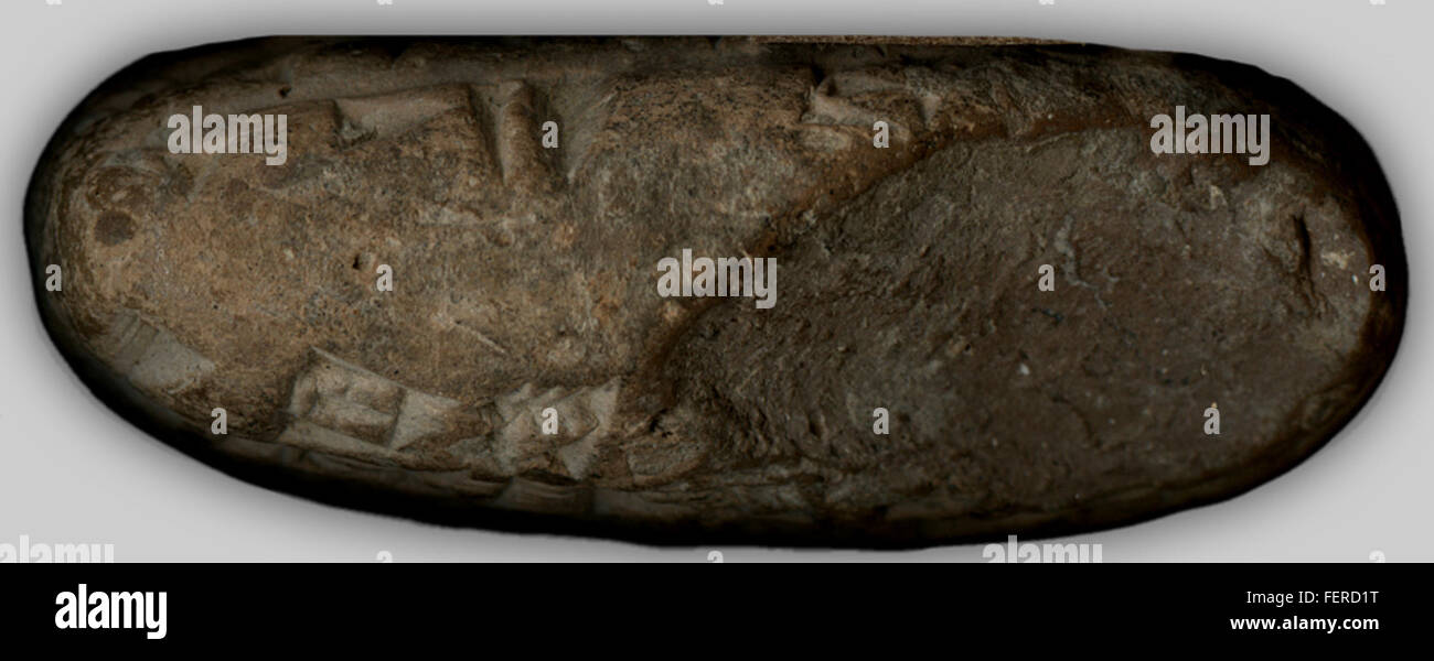 A photograph of the top edge of a cuneiform tablet, which features ...