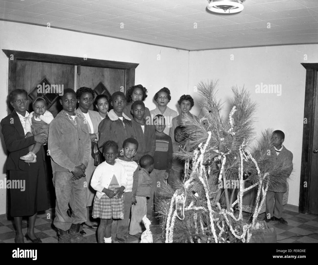 A historical photograph showing a group of people gathered around a ...
