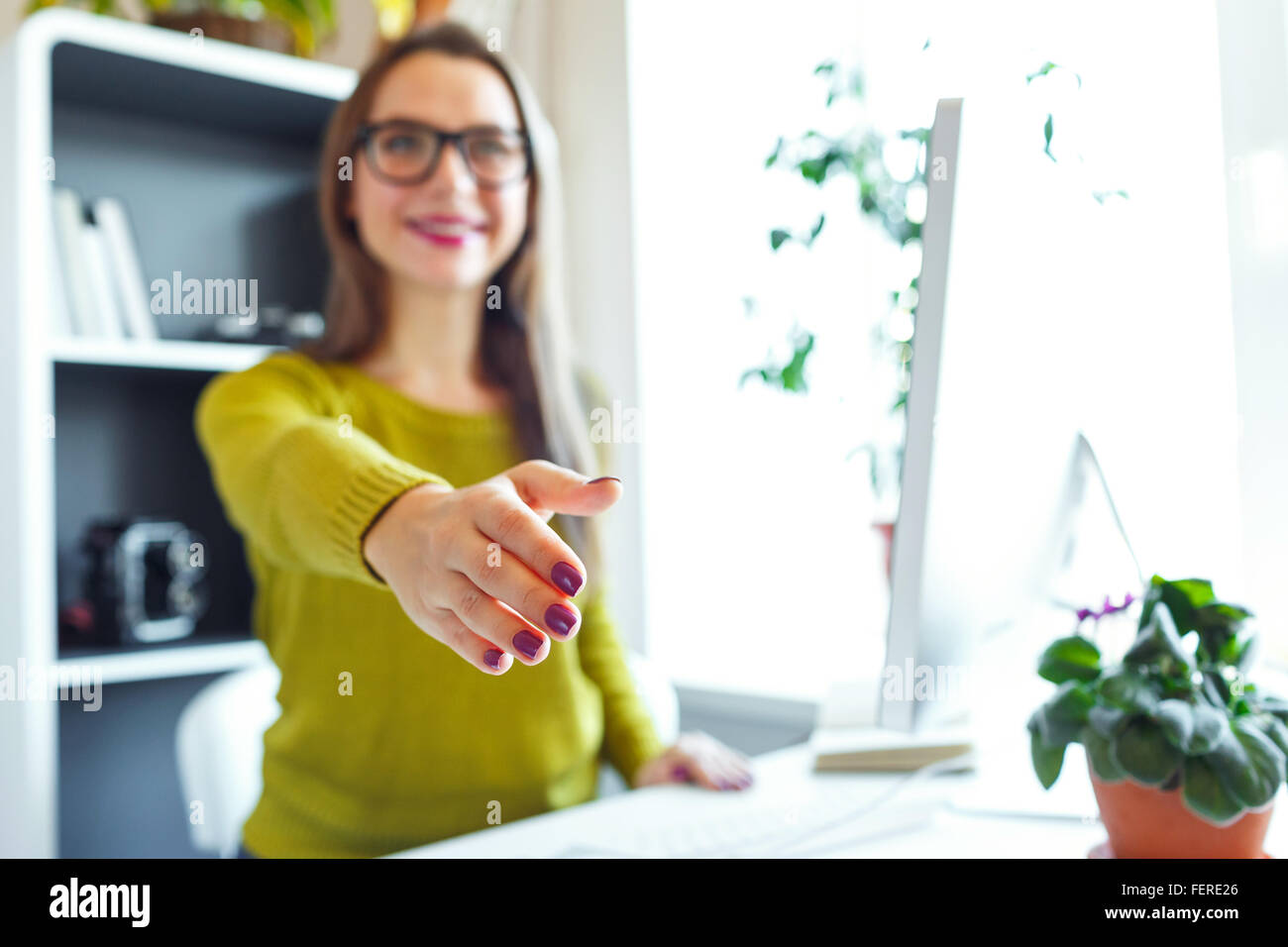 Modern business woman with arm extended to handshake Stock Photo - Alamy