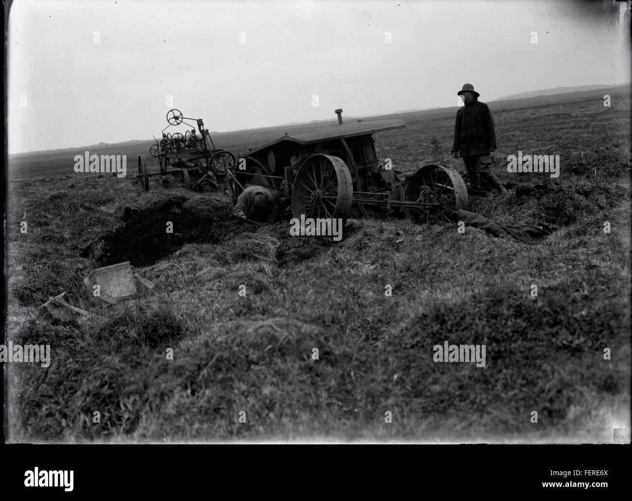 A photograph depicting a tractor stuck at the halfway point of a task ...