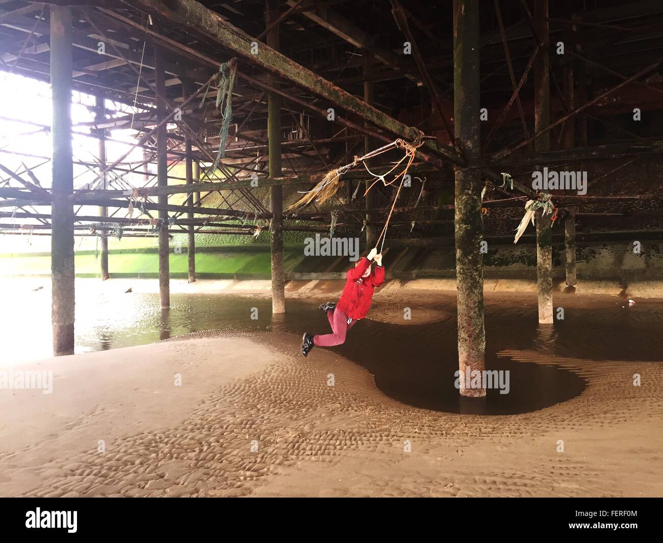 Boy Hanging From Metallic Pole Over River Stock Photo - Alamy