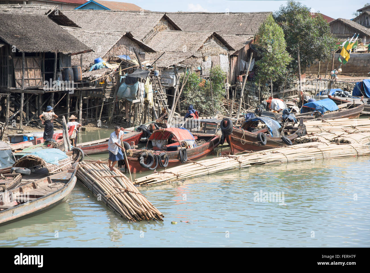 Traditional homes and wooden boats at a canal in Myeik, Southern ...
