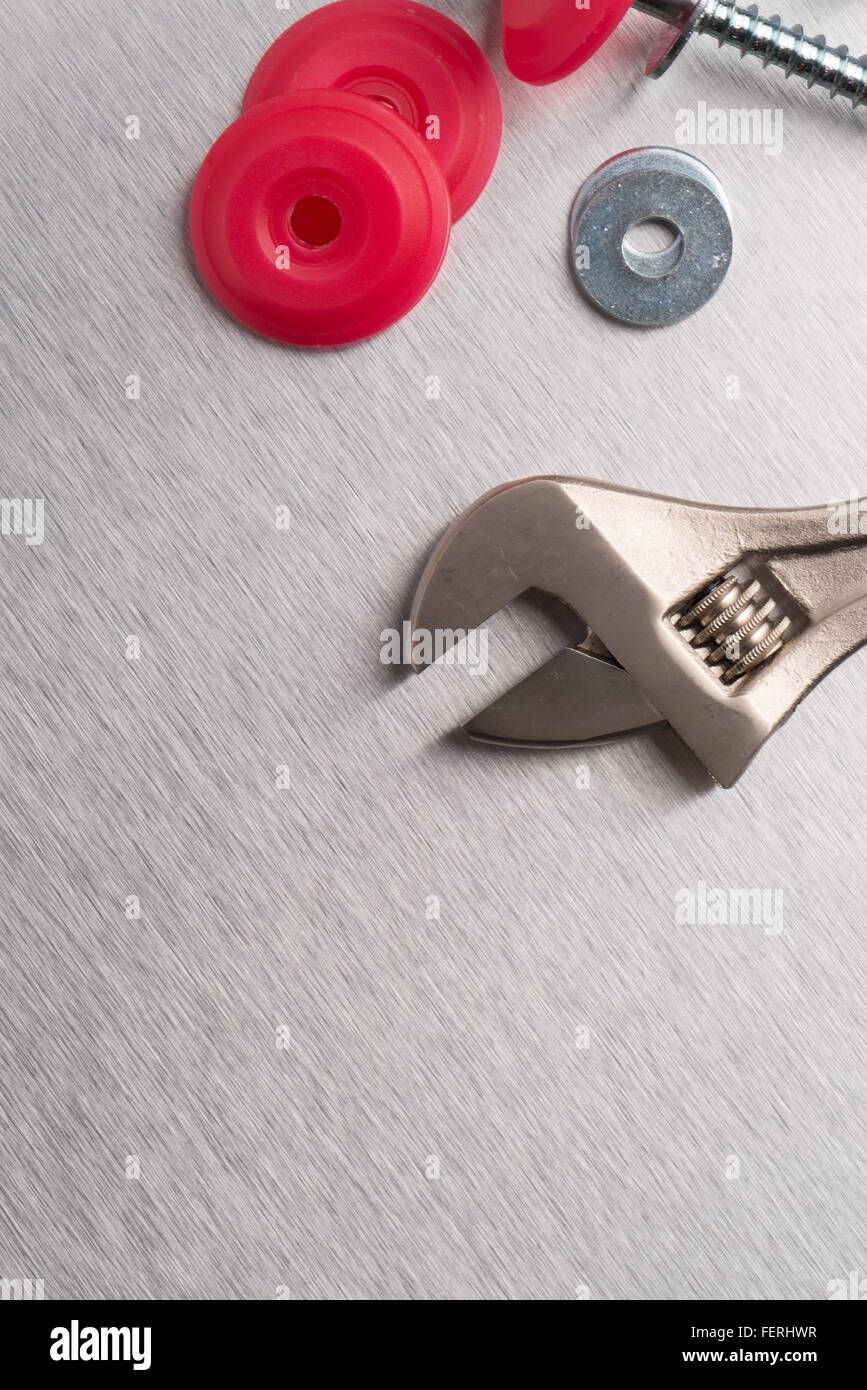 Spanner tool and screws on metal finish background Stock Photo - Alamy