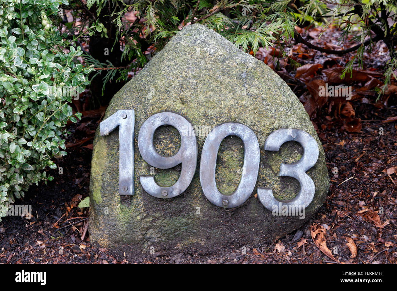 1903 metal house numbers on large rock in garden Stock Photo - Alamy