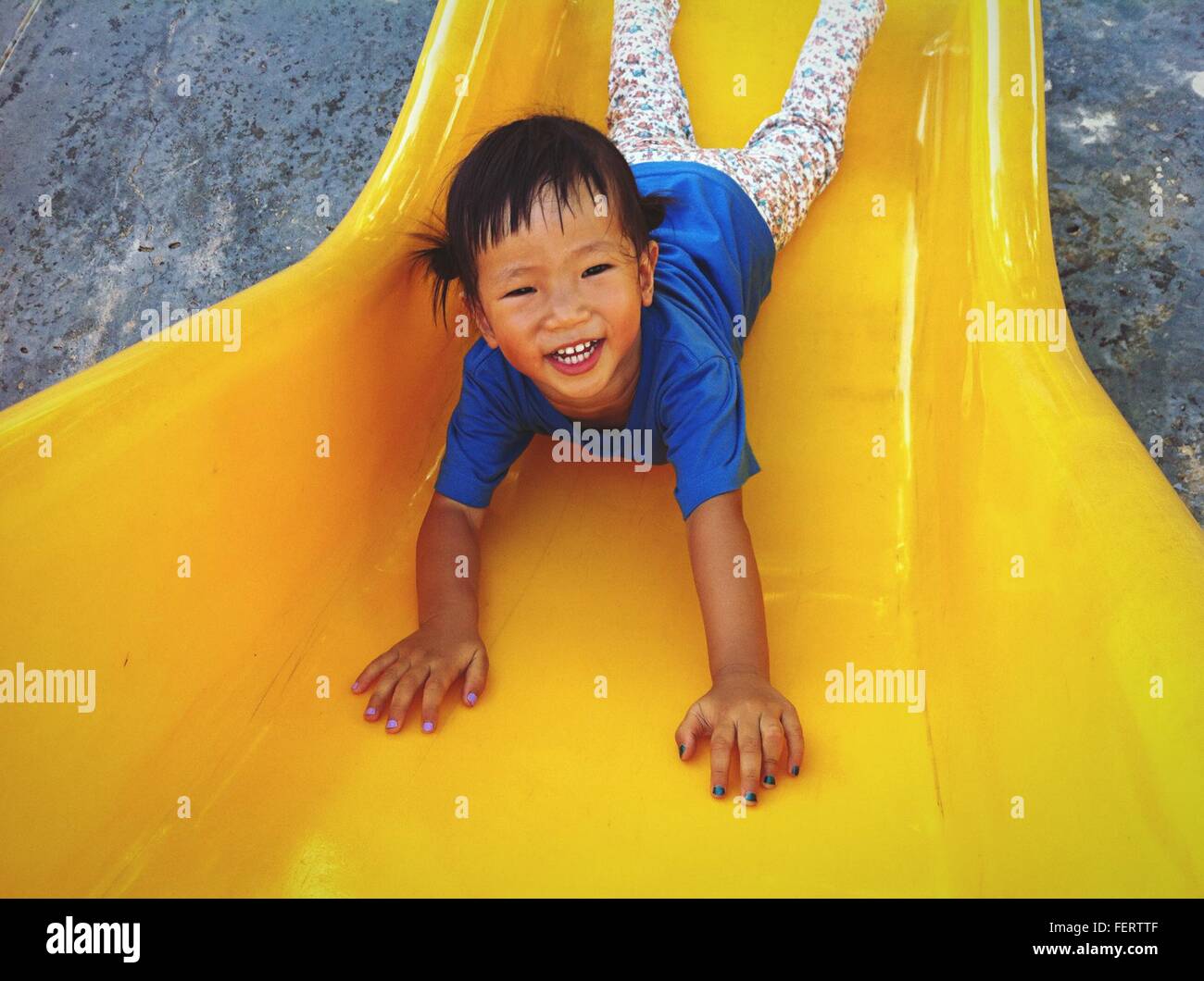 Girl on playground slide hi-res stock photography and images - Alamy