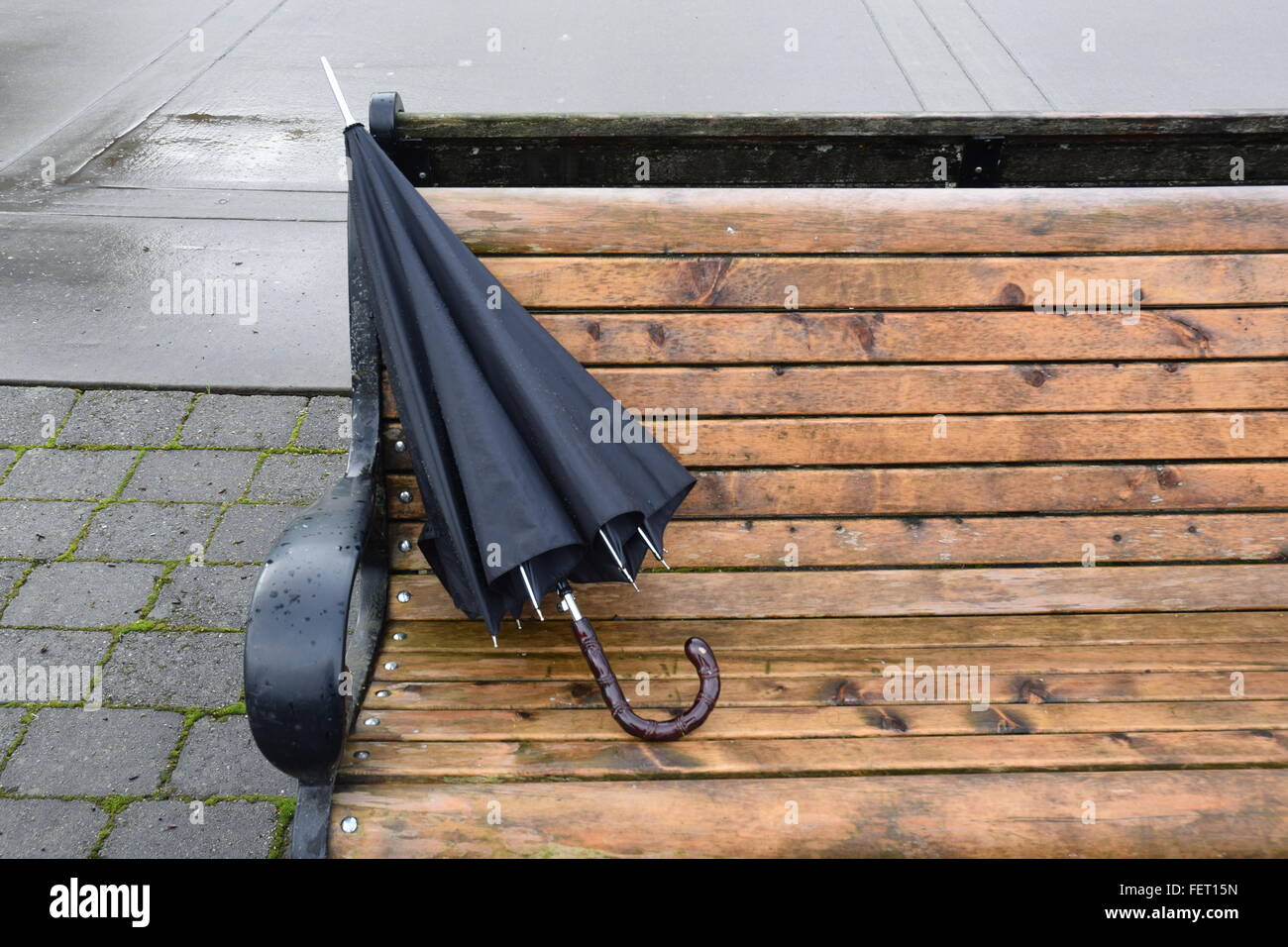 Black umbrella on park bench Stock Photo - Alamy