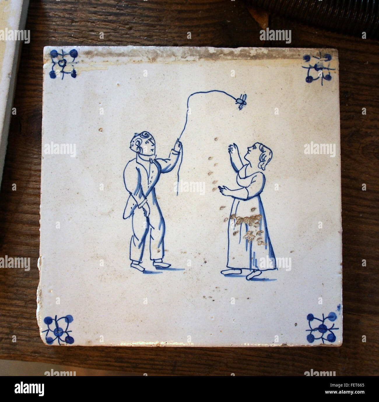 Delftware tiles depicting a woman and a man holding a fly on a string ...
