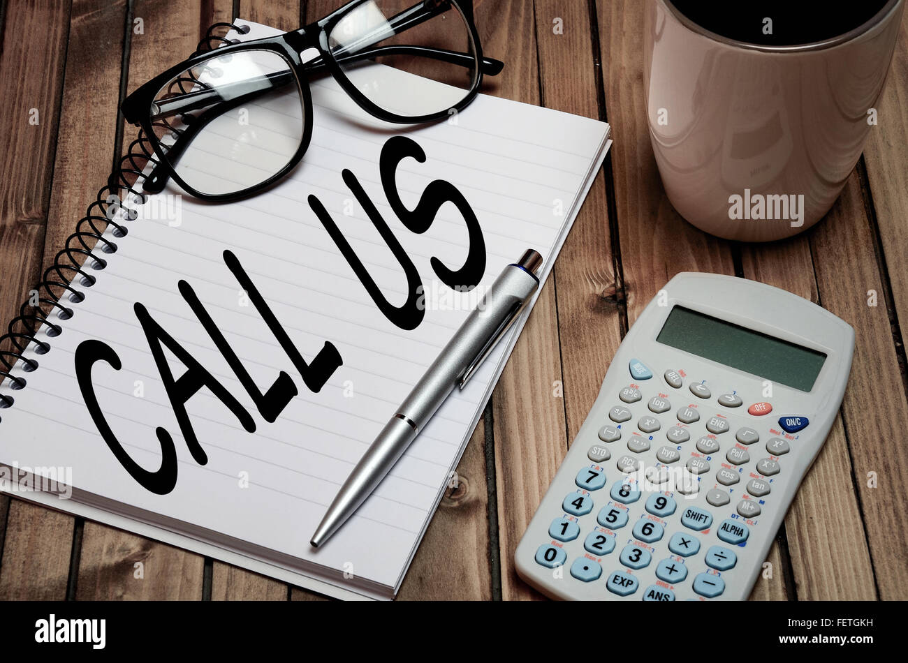 Call us word on notepad Stock Photo - Alamy
