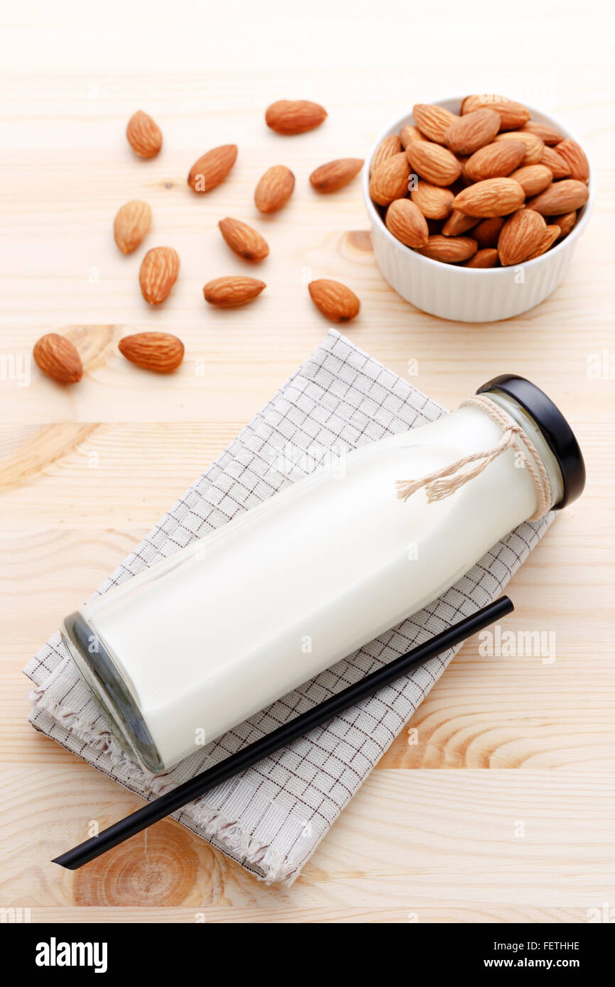 Almond milk in bottle with almonds and straw on wood background Stock ...
