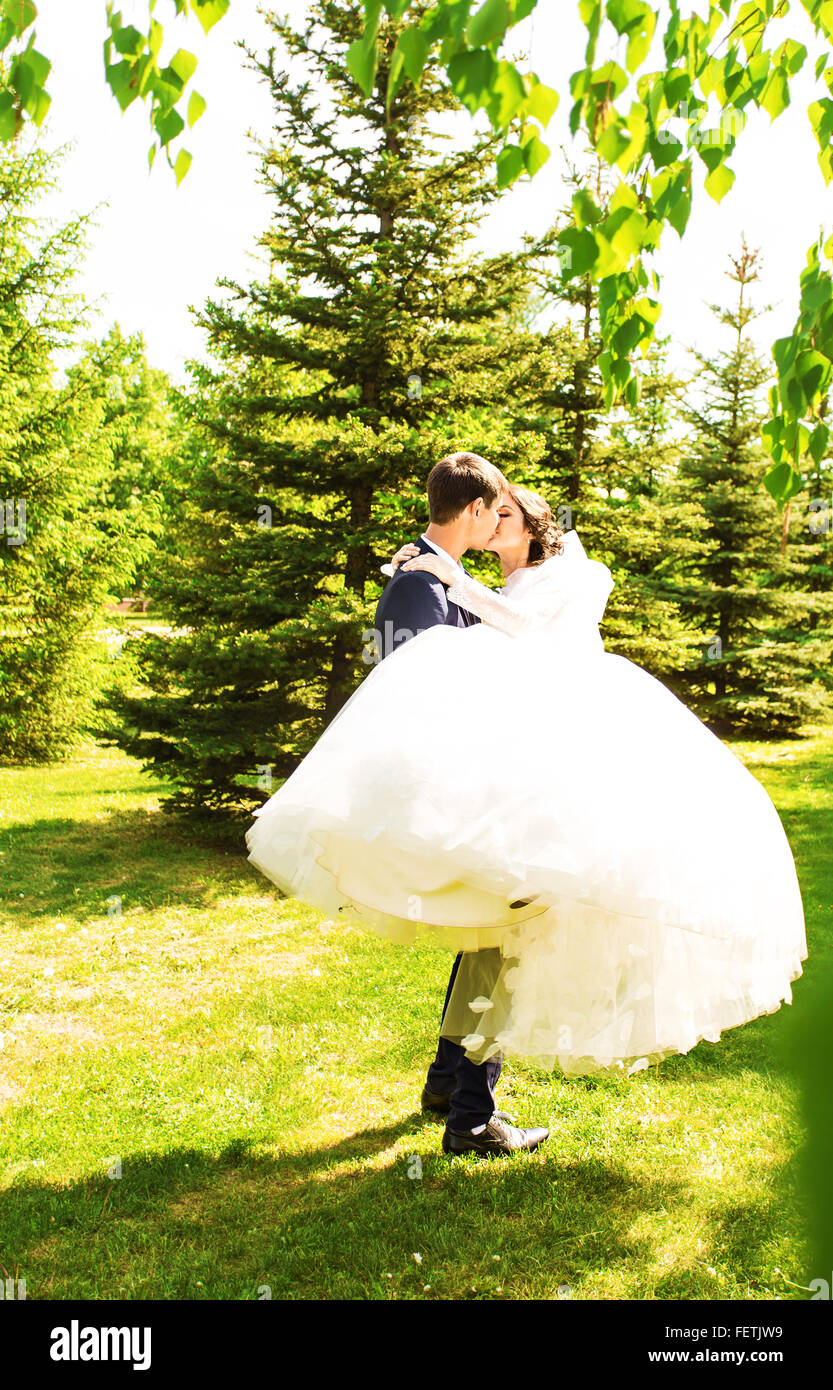 Beautiful wedding couple in park. They kiss and hug each other Stock ...