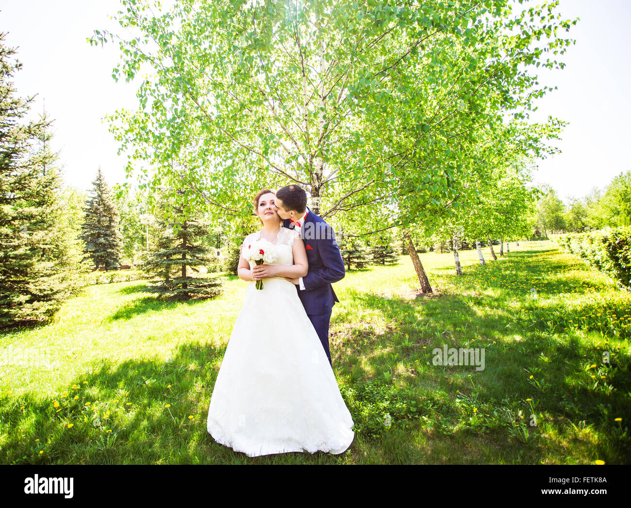 Beautiful wedding couple in park. They kiss and hug each other Stock ...