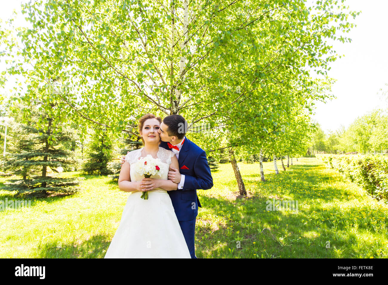 Beautiful wedding couple in park. They kiss and hug each other Stock ...