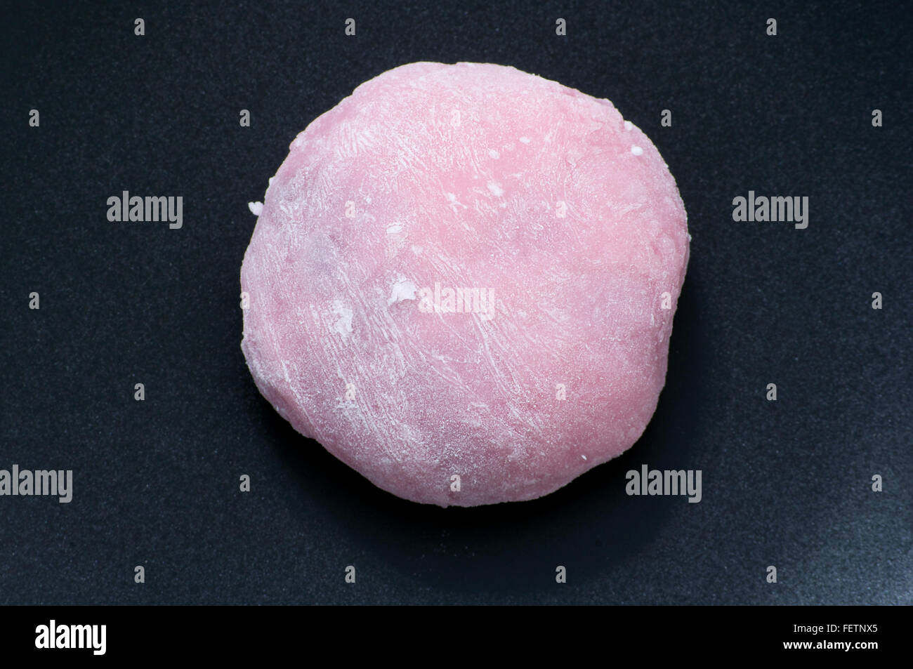 Pink mochi japanese sweet rice treat with filling on the black plate close up Stock Photo - Alamy