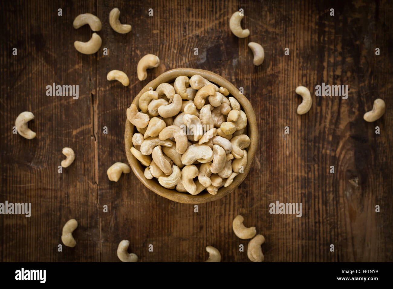 Raw cashew nuts in bowl on textured wooden background, table top view ...