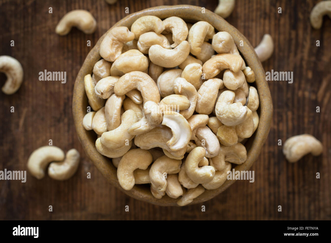 Raw cashew nuts in bowl on textured wooden background, table top view ...