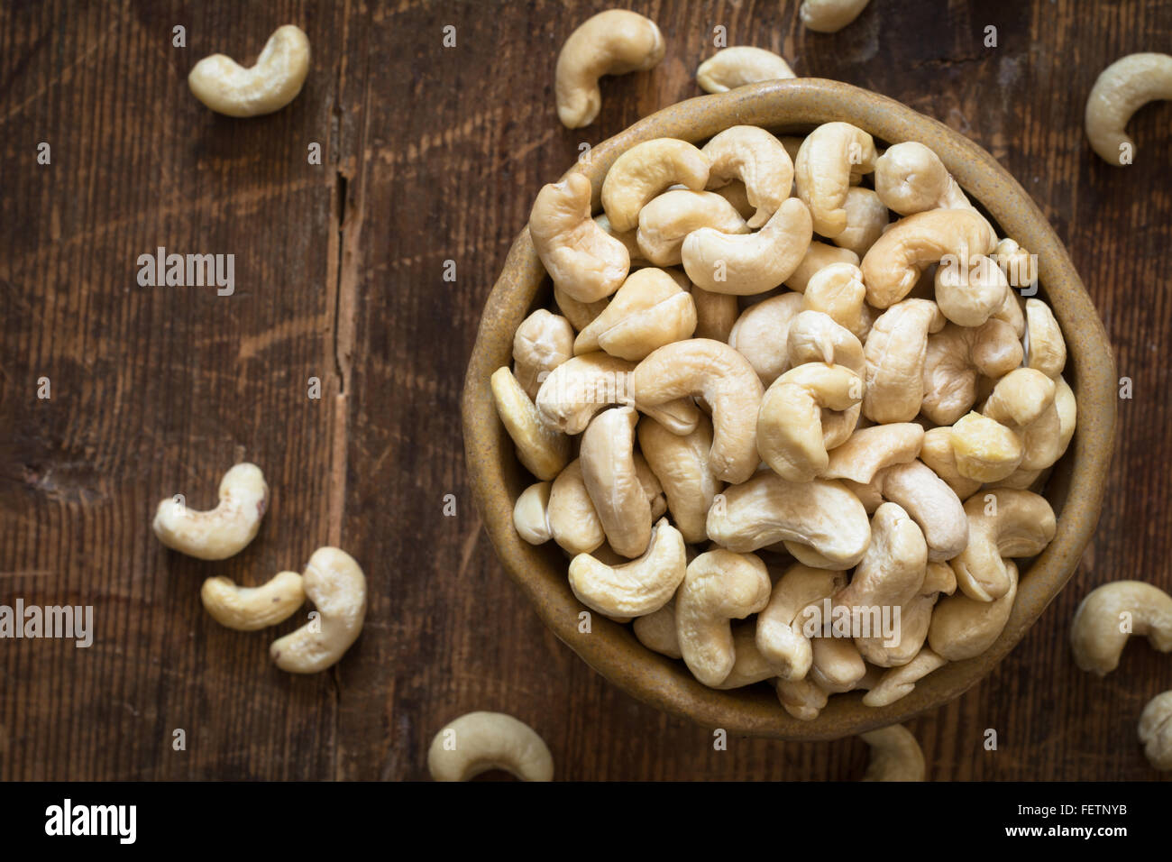 Raw cashew nuts in bowl on textured wooden background, table top view ...