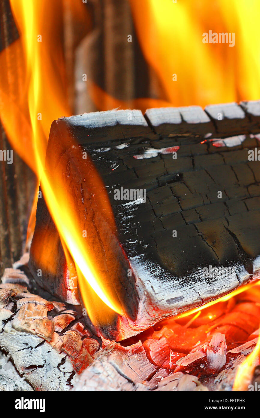 Yellow and orange flames from a burning log campfire Stock Photo - Alamy