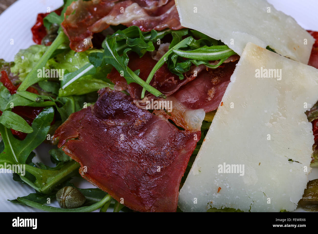 Salad with prosciutto, parmesan, dry tomato and ruccola Stock Photo - Alamy