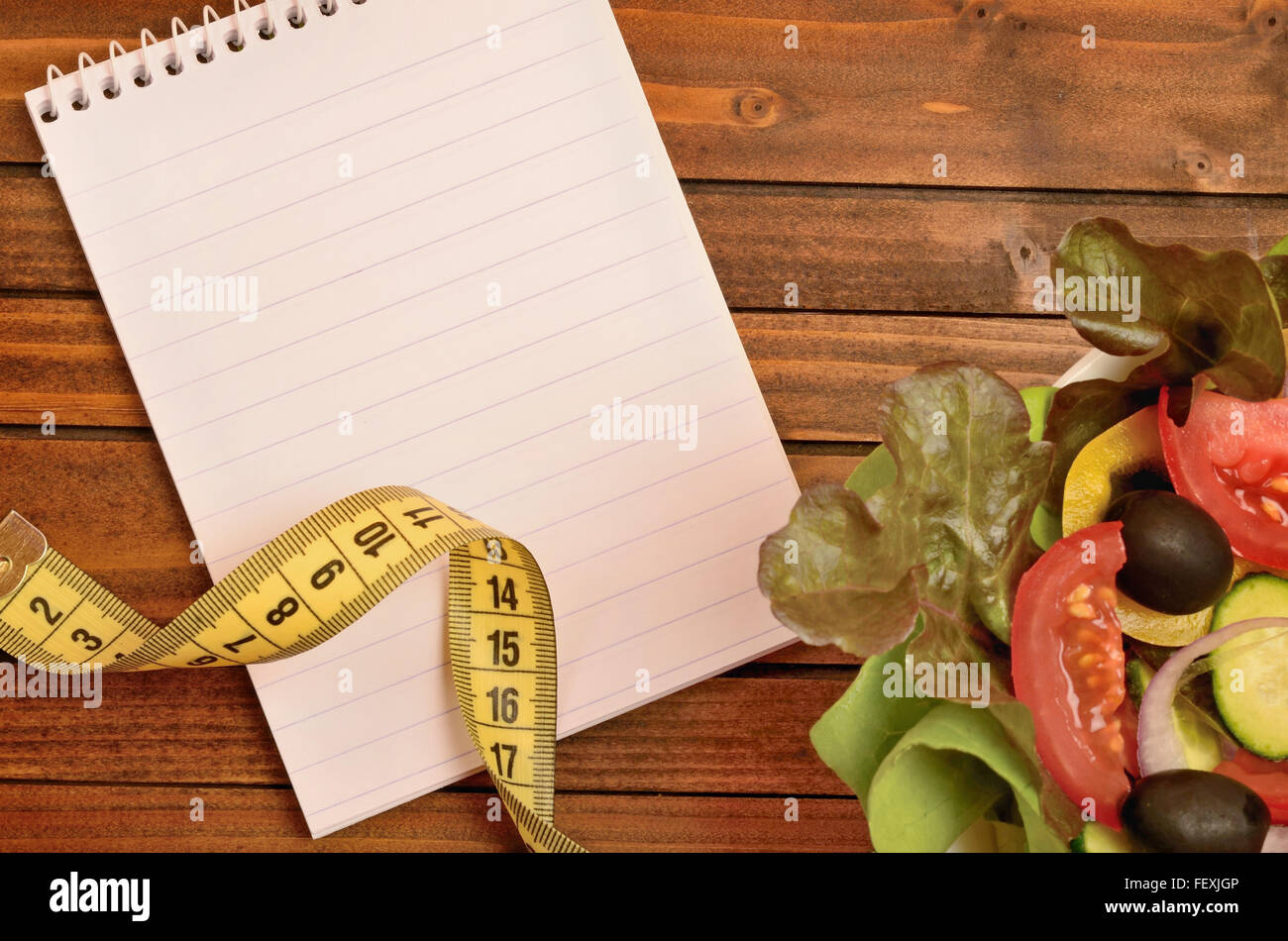 Notepad with centimeter and vegetable salad Stock Photo - Alamy