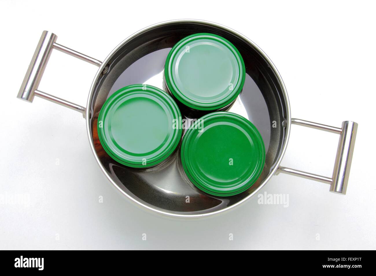 Steel pot with three jars inside boiling in water. Isolated on white ...