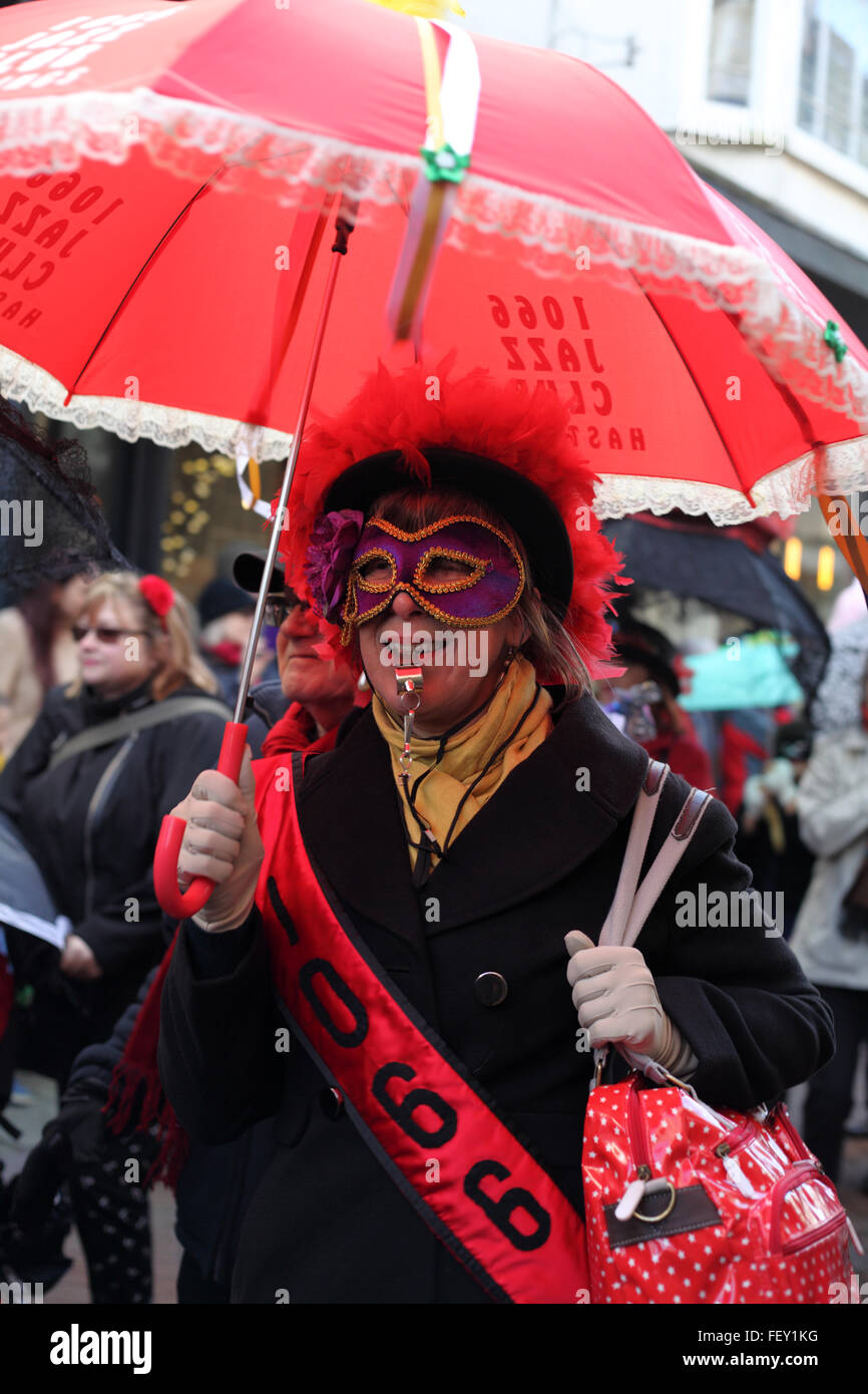 Local lady wearing a mask and carrying a bright red umbrella during ...