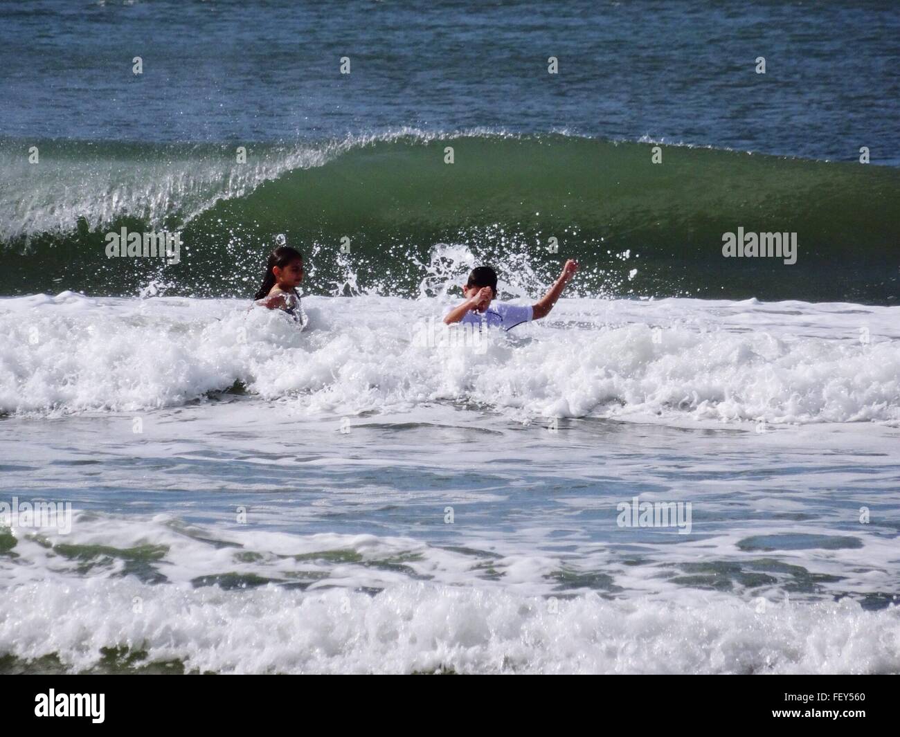 Children Playing In The Waves High Resolution Stock Photography and ...