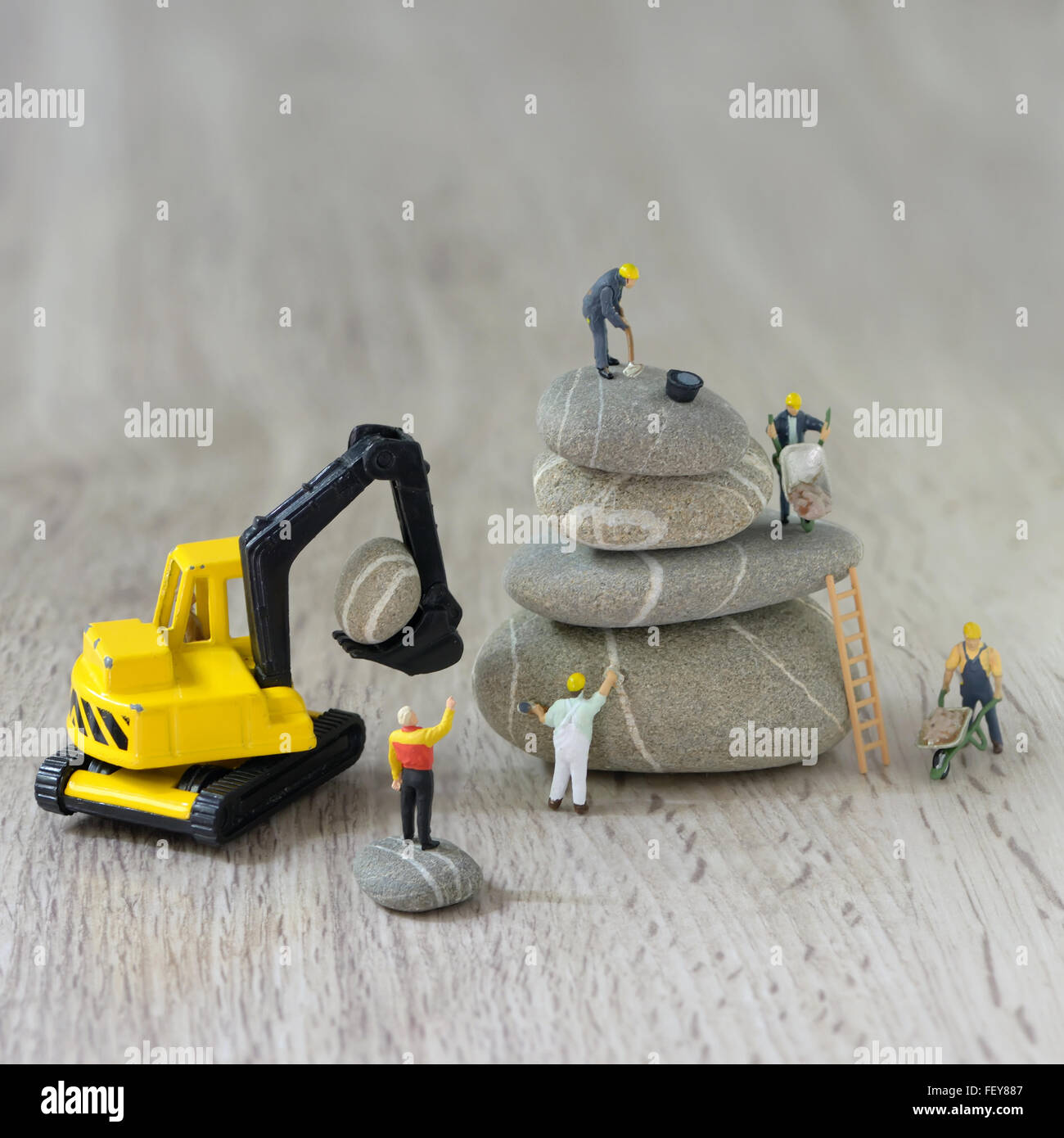 Construction site with miniature workers and pebbles Stock Photo - Alamy