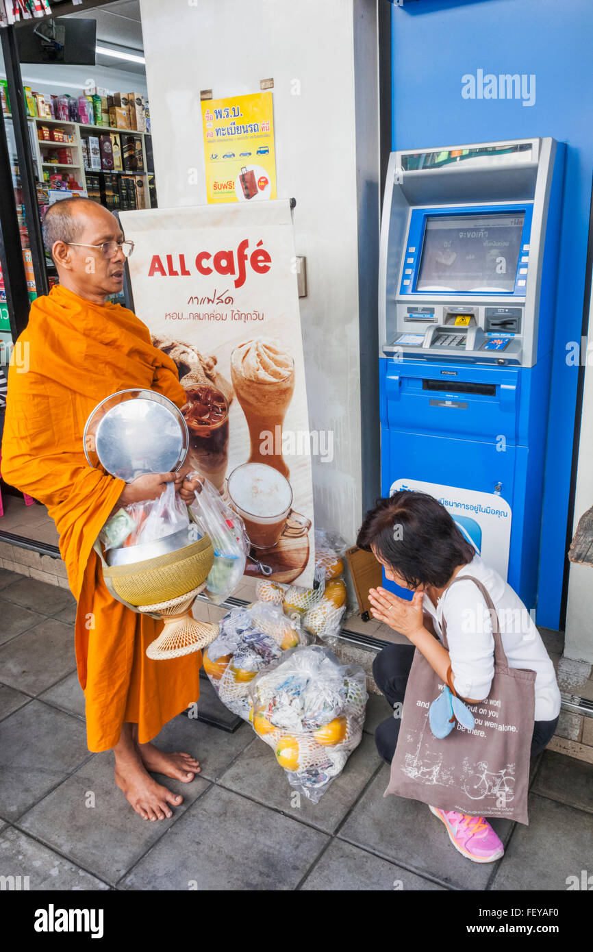 Thailand, Bangkok, Lady Giving Offerings to Monk Stock Photo - Alamy