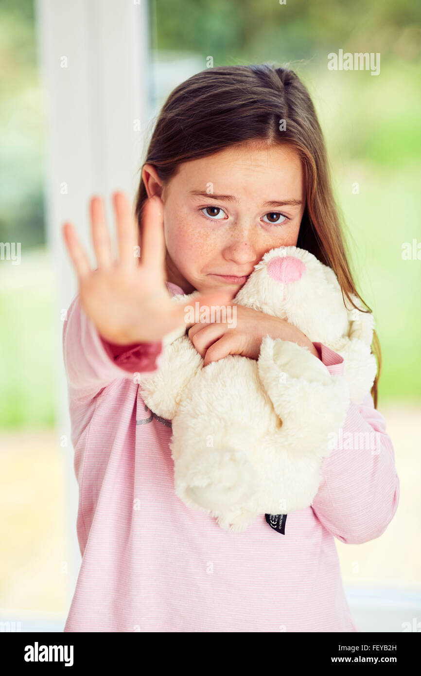 Girl sat alone holding hand out Stock Photo - Alamy