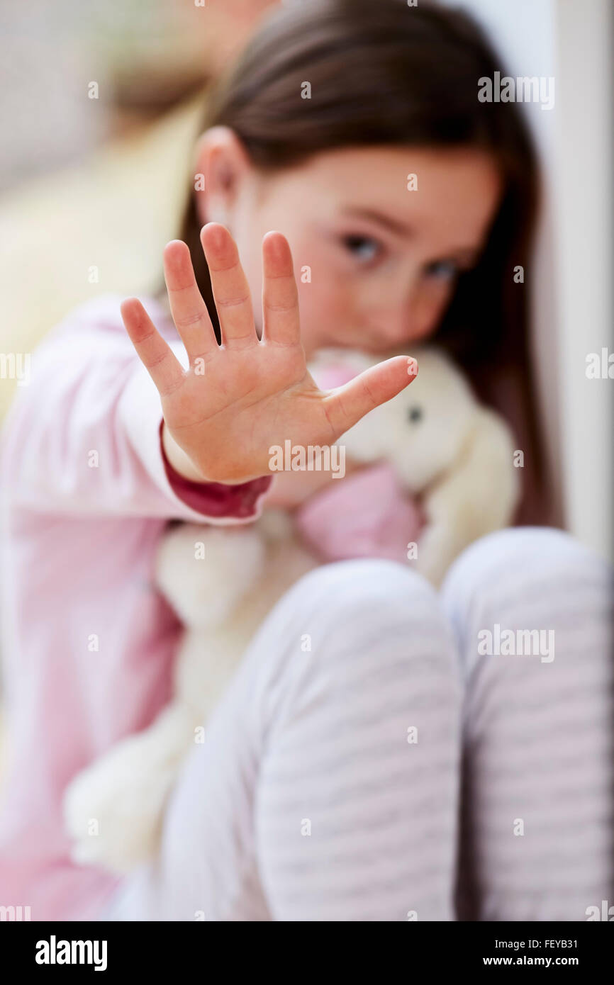 Girl sat alone holding hand out Stock Photo - Alamy