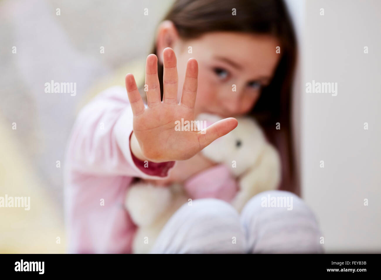 Girl sat alone holding hand out Stock Photo - Alamy