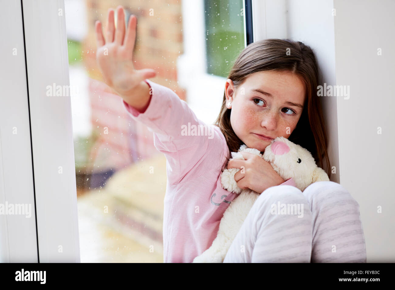 Girl sat alone holding hand out Stock Photo - Alamy