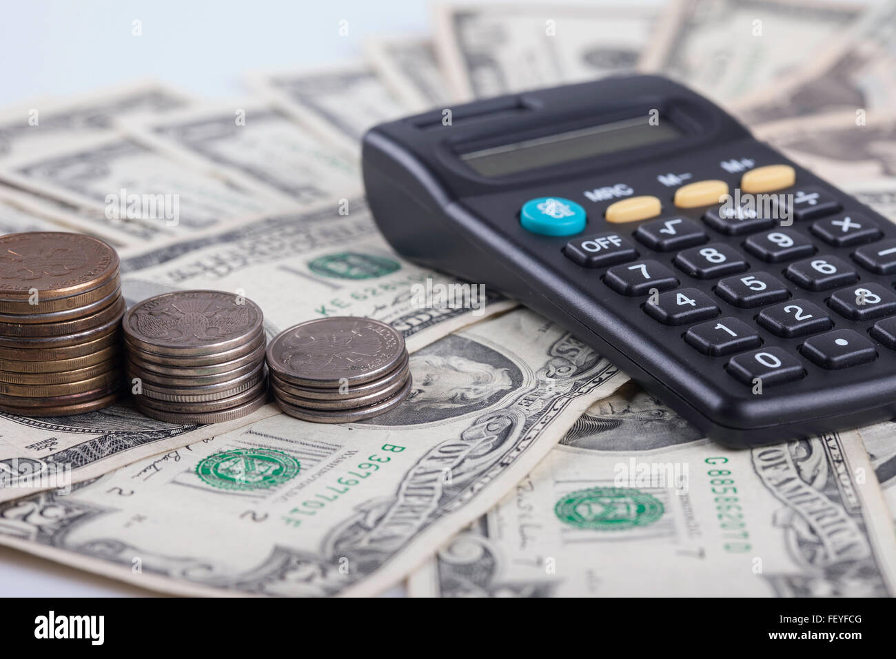 coins and calculator on the background of dollar banknotes Stock Photo ...