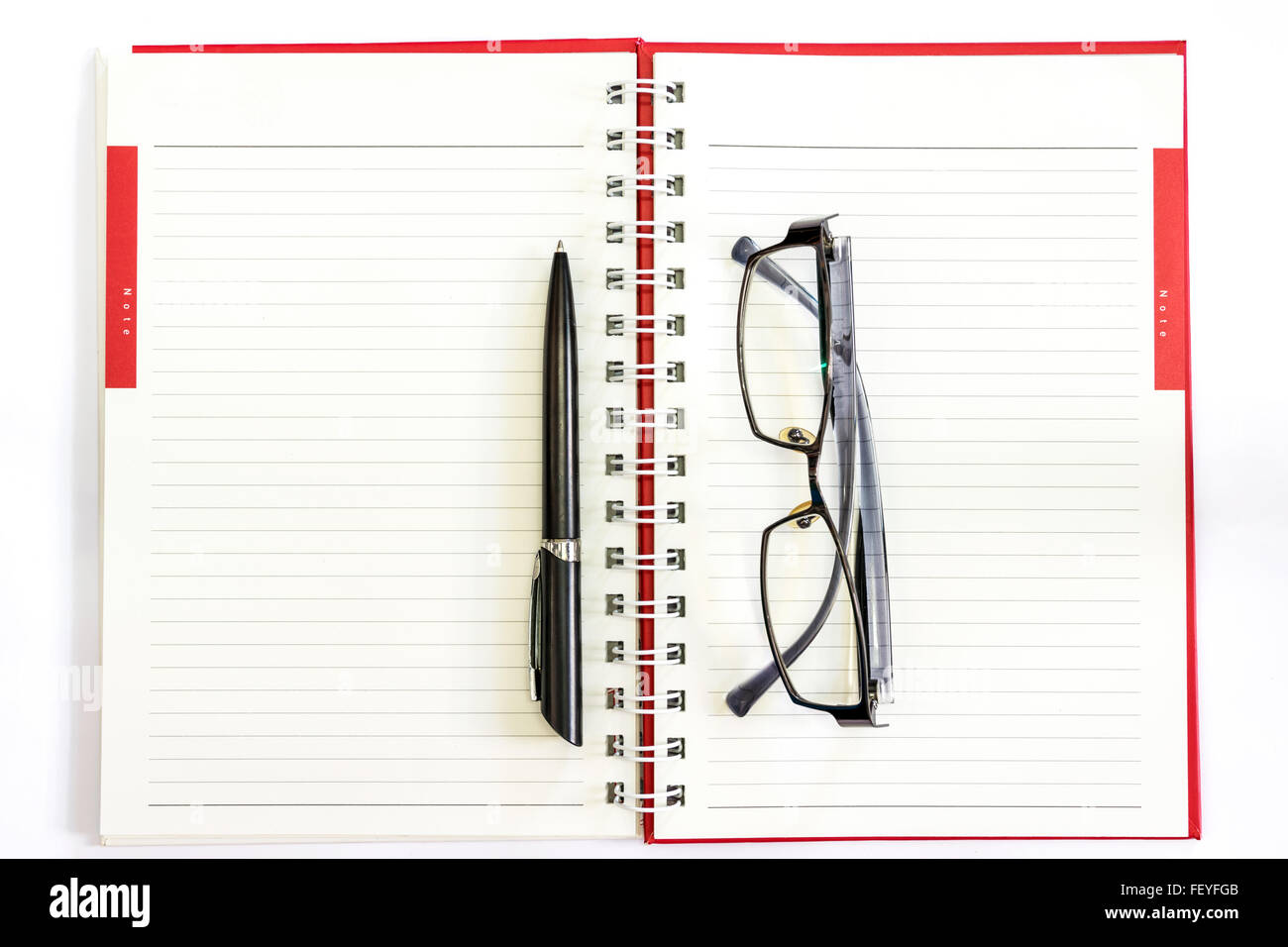 Pen and eyeglasses resting on a notebook Stock Photo - Alamy