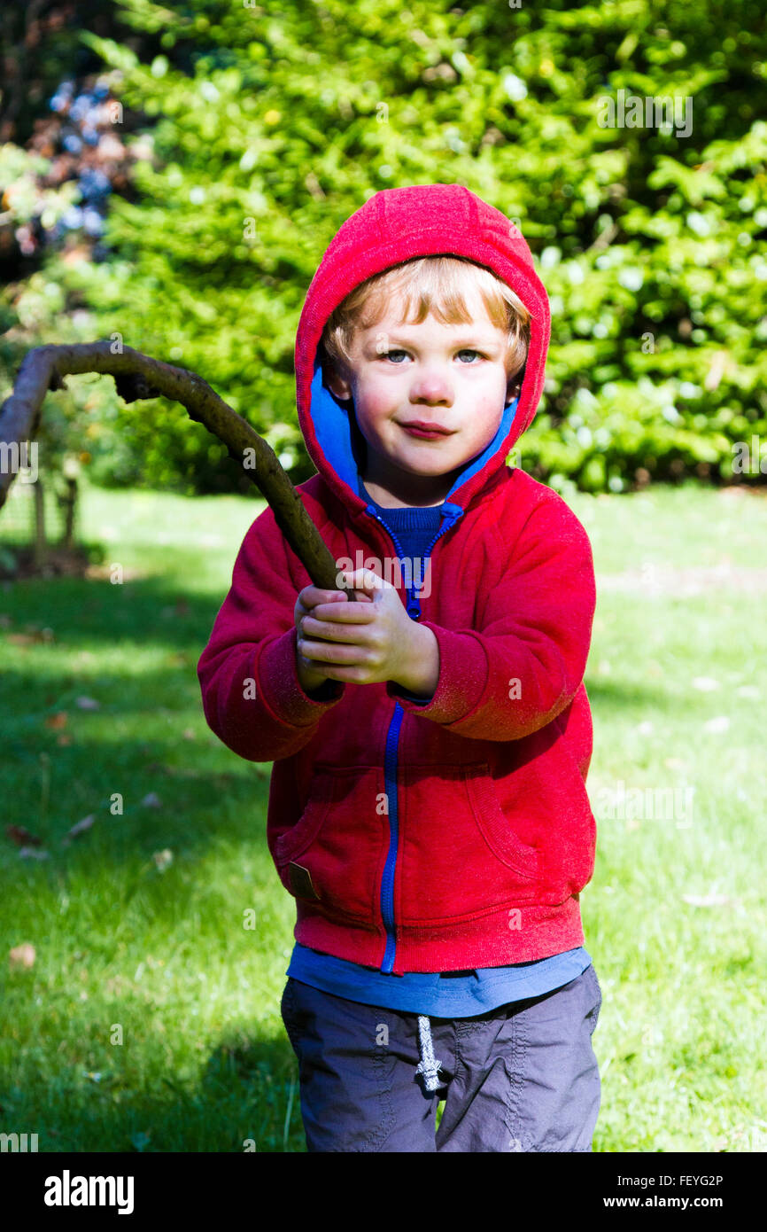 Young boy playing outdoors with a stick Stock Photo - Alamy